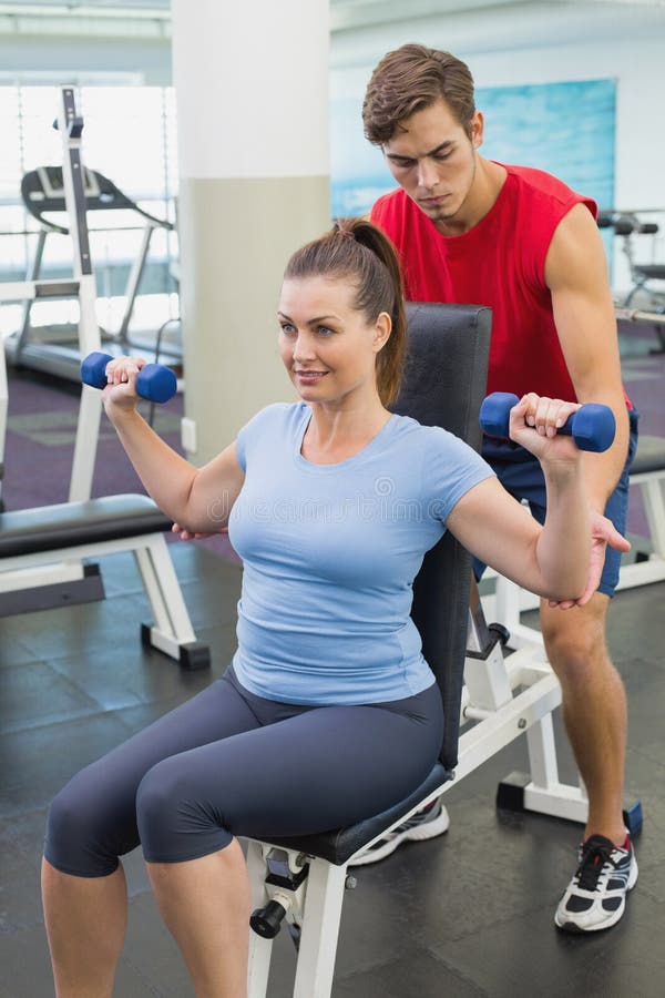 Personal Trainer Helping Client Lift Dumbbells Stock Photo - Image of ...