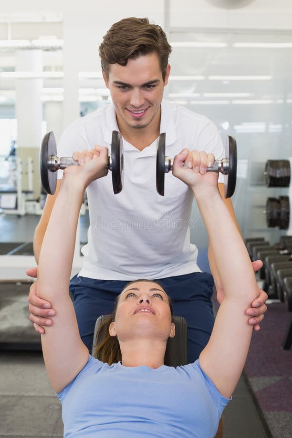 Personal Trainer Helping Client Lift Dumbbells Stock Image - Image of ...