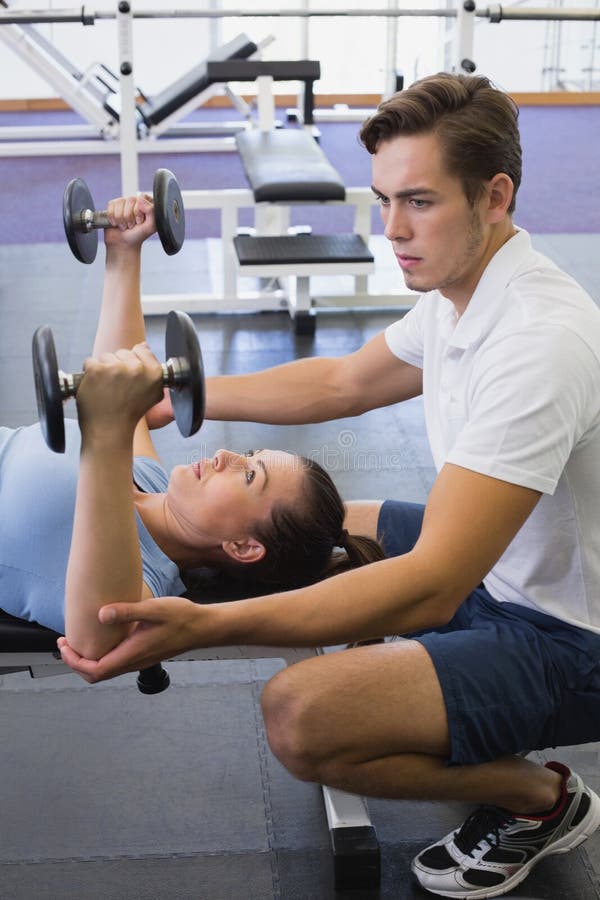 Personal Trainer Helping Client Lift Dumbbells Stock Photo - Image of ...