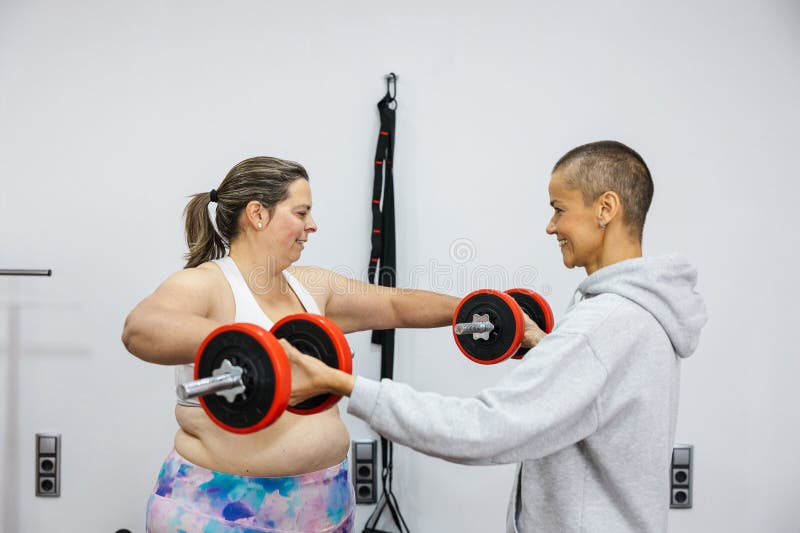 Personal Trainer Helping Client with Shoulder and Back Training Using ...