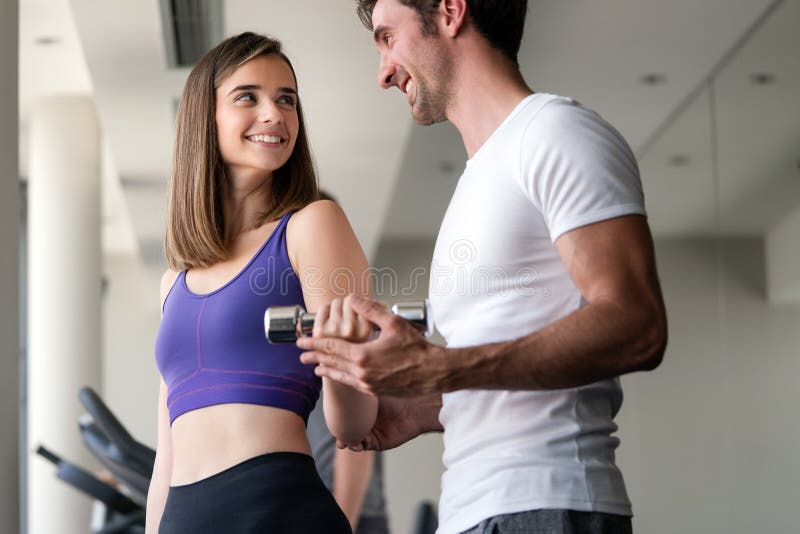 Personal Trainer Helping Woman Working With Dumbbells Stock Image