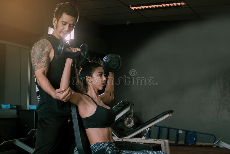 Personal Trainer Helping Woman Working Lift Heavy Dumbbells Two Hand