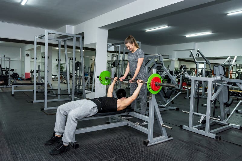 Personal Trainer Helping Work with Barbell in Gym Stock Photo - Image ...