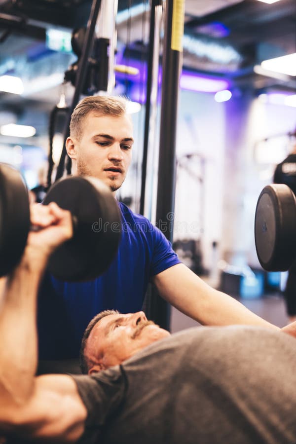 Personal Trainer Instructing Older Man during Exercise. Stock Image ...