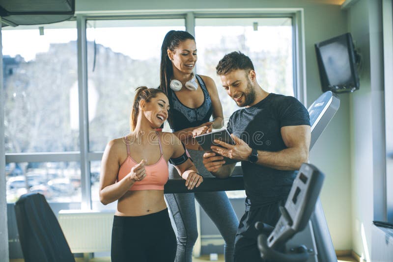 Personal Trainer Looking at Digital Tablet and Explaining Progress To ...