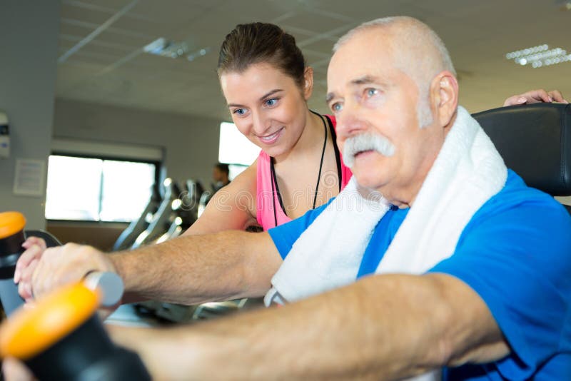 Personal Trainer with Senior Man in Gym Stock Image - Image of ...