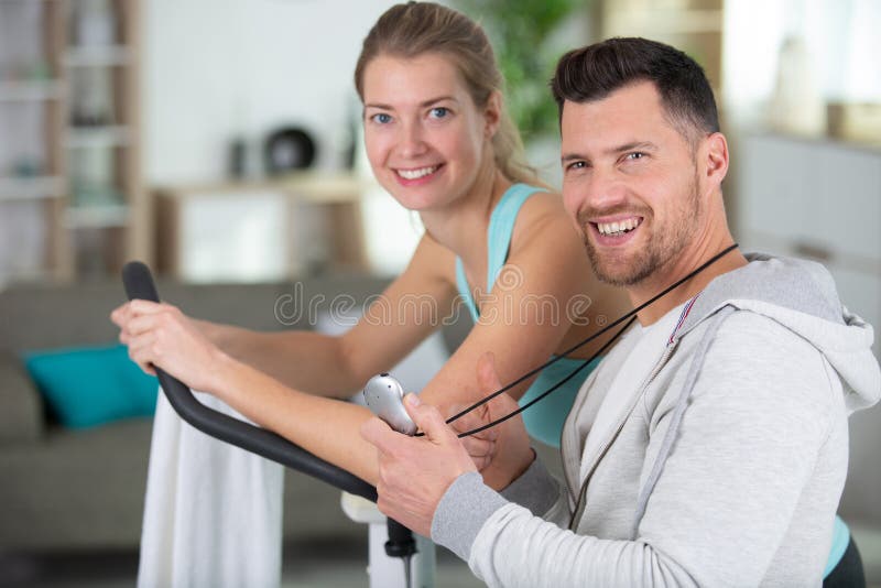 Personal Trainer with Stopwatch with Woman on Exercise Machine Stock ...
