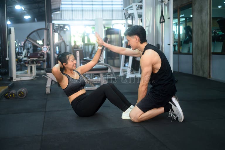 Personal Trainer Supporting His Client during an Abdominal Workout in ...