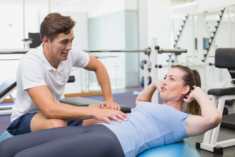 Personal Trainer Working with Client on Exercise Ball Stock Photo ...