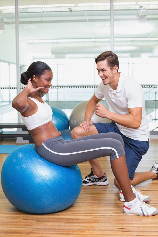 Personal Trainer Working with Client on Exercise Ball Stock Photo ...