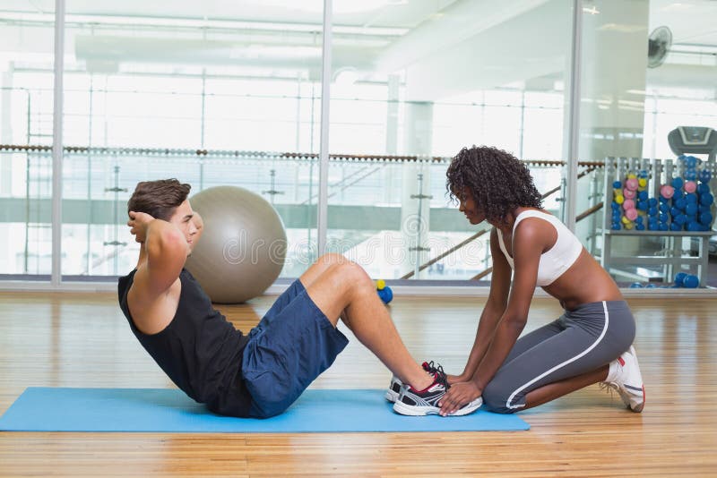 Personal Trainer Working with Client on Exercise Mat Stock Photo ...