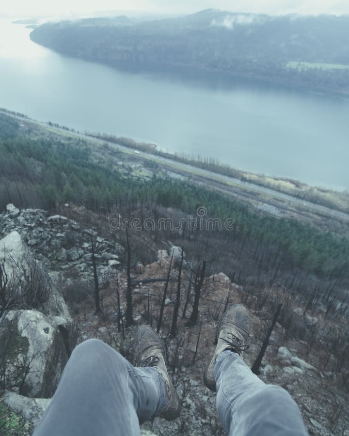 Persons`s Feet Sitting on the Edge of a Steep Rocky Hill Stock Image ...