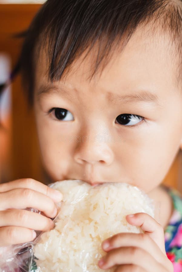 Petite Fille D'enfant Mangeant Du Riz Collant Photo stock - Image du ...