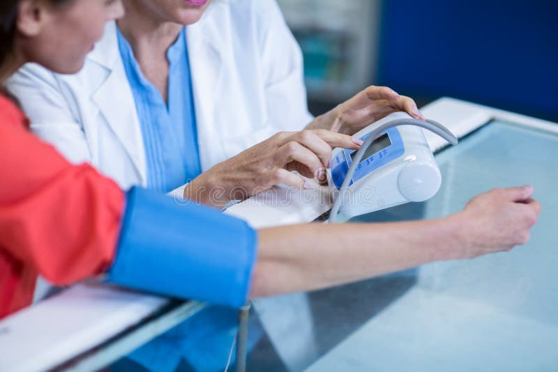 Pharmacist Checking Blood Pressure of Customer Stock Photo - Image of ...