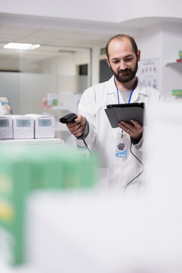 Pharmacist Checking Medication List on Tablet Computer while Scanning ...