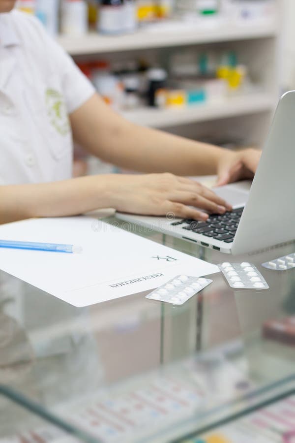Pharmacist with Laptop Computer and Medication in the Pharmacy Stock ...