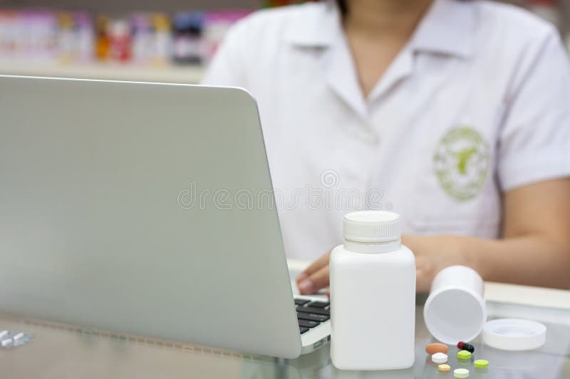 Pharmacist with Laptop Computer and Medication in the Pharmacy Stock ...