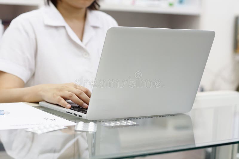 Pharmacist with Laptop Computer and Medication in the Pharmacy Stock ...