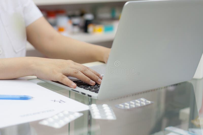 Pharmacist with Laptop Computer and Medication in the Pharmacy Stock ...