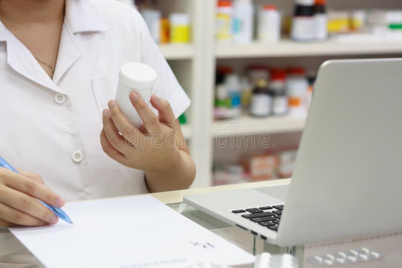 Pharmacist with Laptop Computer and Medication in the Pharmacy Stock ...