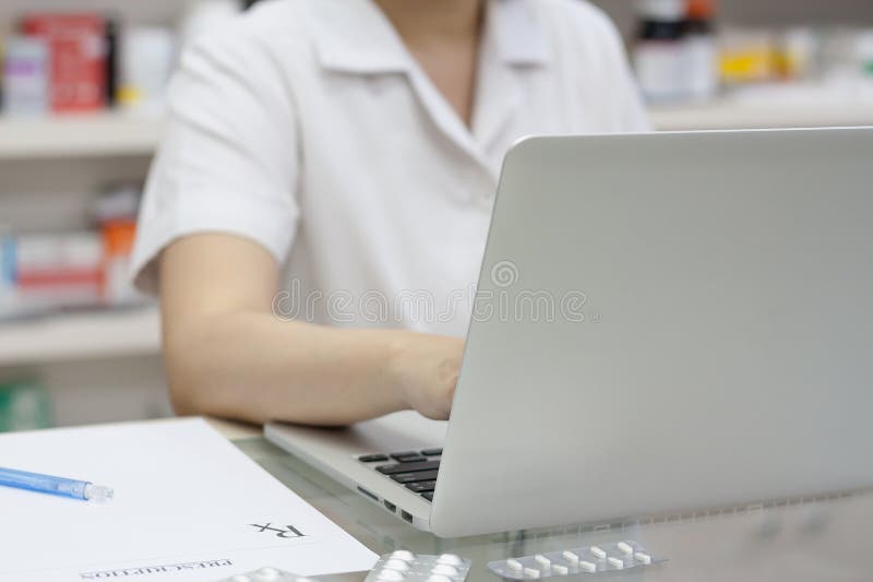 Pharmacist with Laptop Computer and Medication in the Pharmacy Stock ...