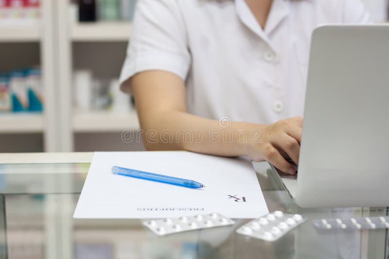 Pharmacist with Laptop Computer and Medication in the Pharmacy Stock ...