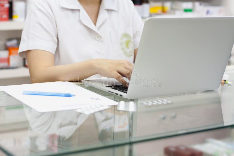 Pharmacist with Laptop Computer and Medication in the Pharmacy Stock ...