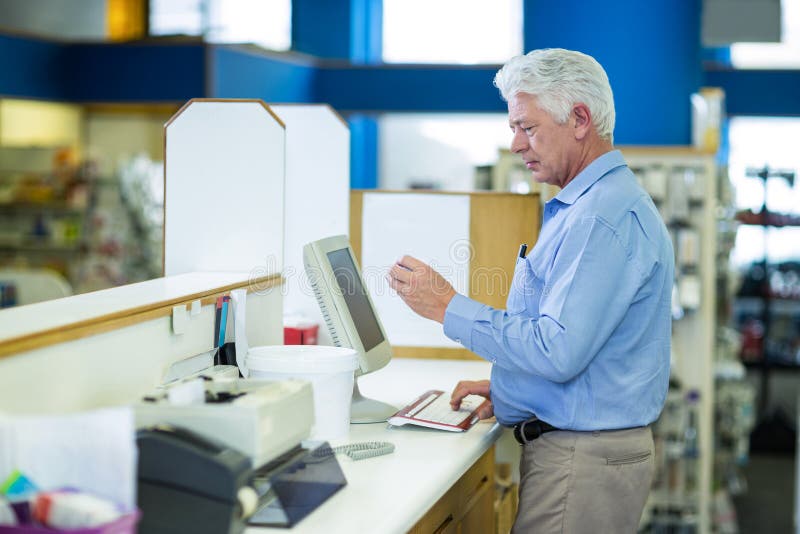 Pharmacist Making Prescription Record through Computer Stock Photo ...