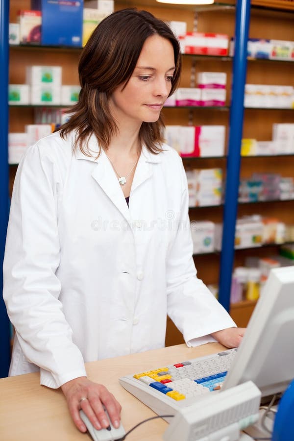 Pharmacist Using Computer at Counter Stock Photo - Image of bottle ...