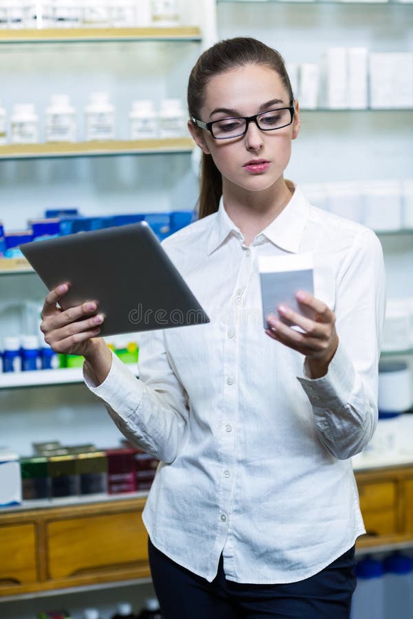 Pharmacist Using Digital Tablet while Checking Medicine Stock Photo ...