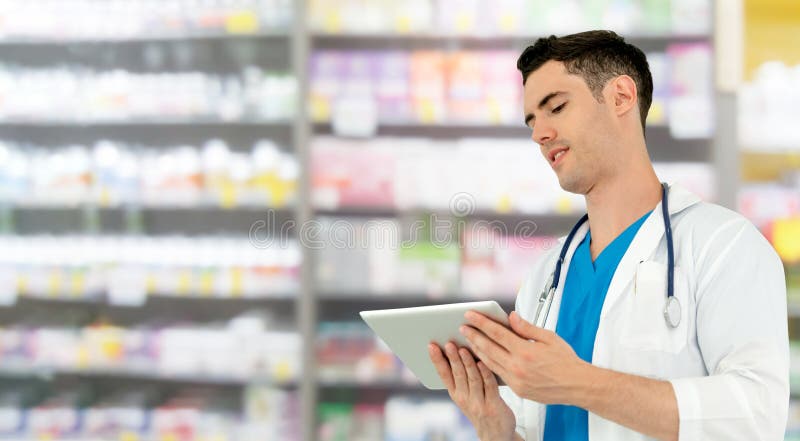 Pharmacist Using Tablet Computer at Pharmacy. Stock Photo - Image of ...