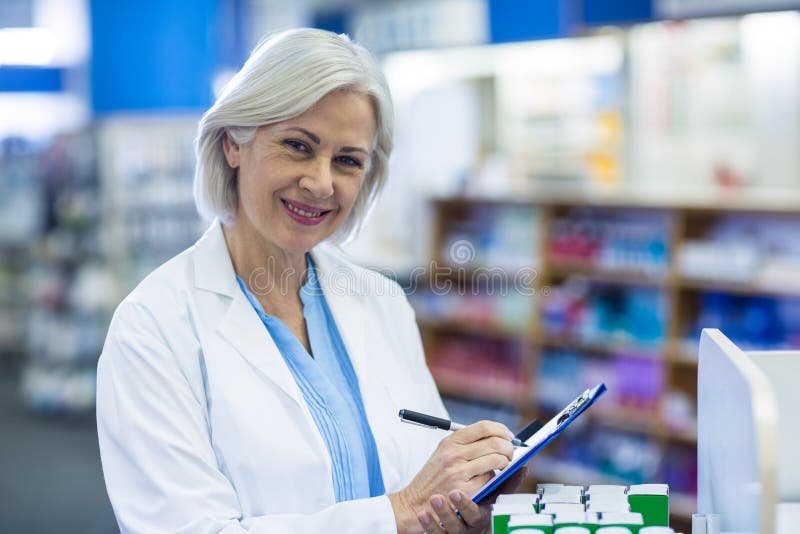 Pharmacist Writing on Clipboard in Pharmacy Stock Image - Image of ...