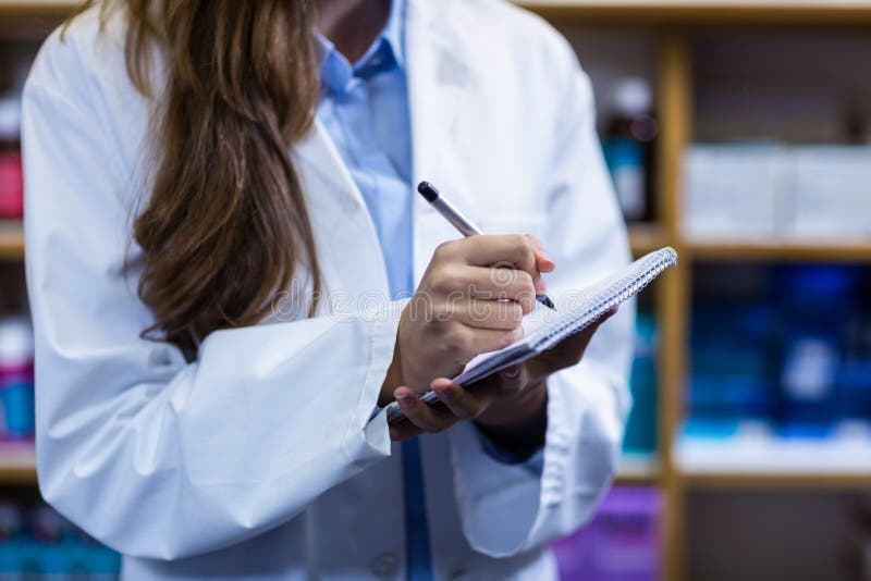 Pharmacist Writing on Notepad in Pharmacy Stock Image - Image of ...