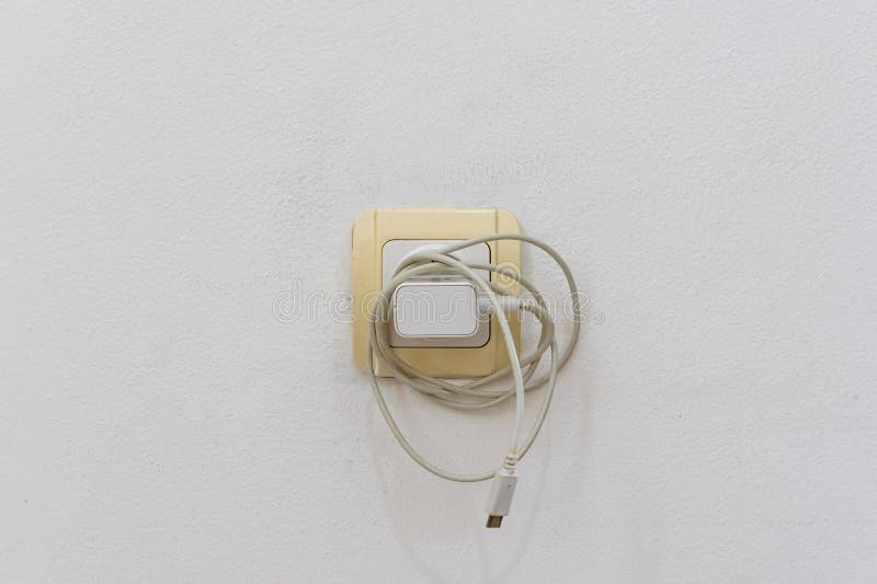 The Phone Charger is Plugged into the Electrical Power Socket on Wall ...