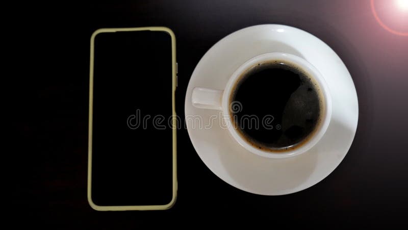 Phone and a Cup of Black Coffee on White Plate on the Table with Light ...
