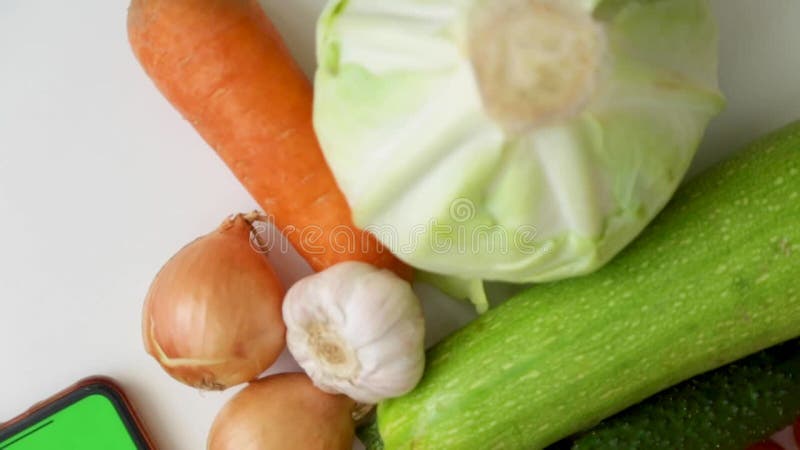 A Phone with a Green Screen is Lying on the Side of the Vegetables and ...