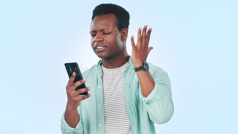 Phone, Stress and Anxiety with an Annoyed Black Man in Studio on a Blue ...