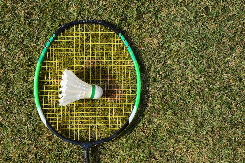 Photo about Badminton Racket and Shuttlecock Isolated on Green Grass ...