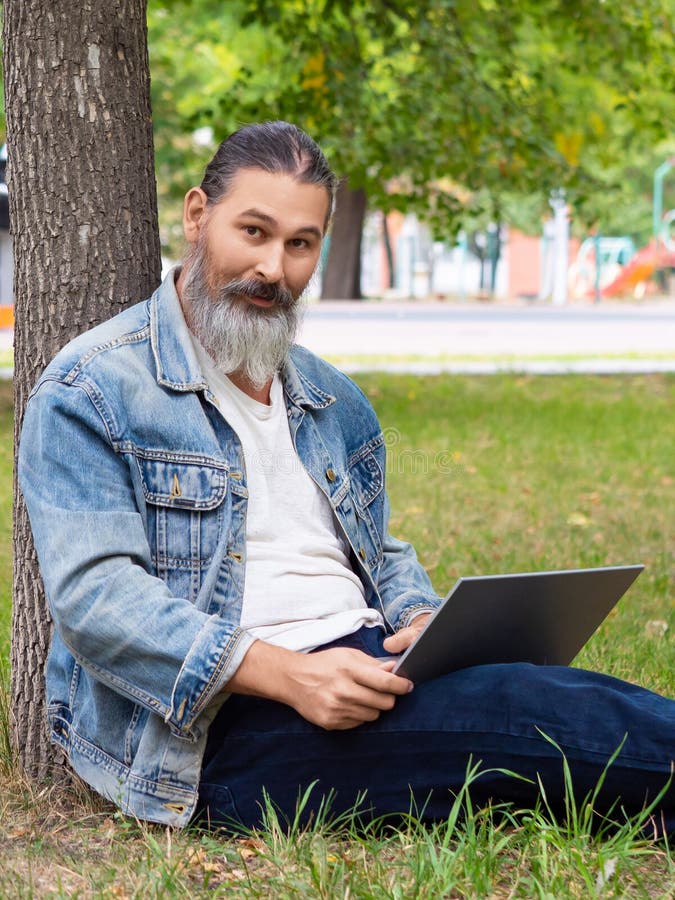 Photo of a Bearded Man while Working Online with a Laptop. he Looking ...