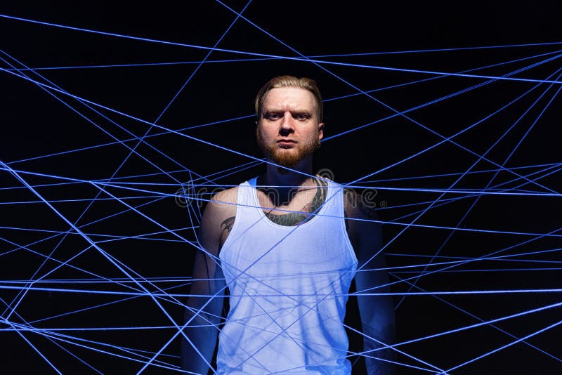 Photo of Blond Man Tangled in White Threads in Neon Light Stock Photo ...