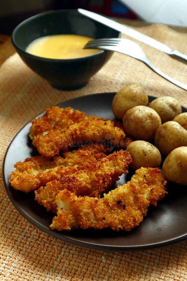Boiled Potatoes and Deep Fried Crispy Fish Strips on a Plate Stock ...