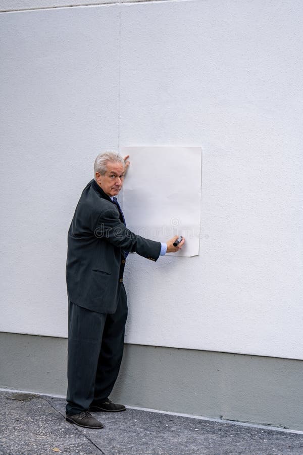 Photo of a Businessman Holding Up a Posterboard Getting Ready To Write ...
