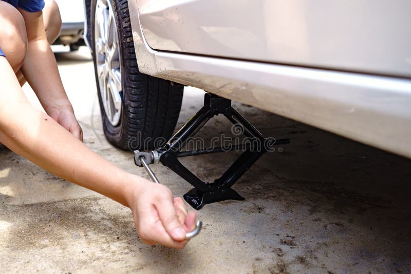 A Photo of a Car Mechanic Using a Jack To Change a Car& X27;s Wheels ...