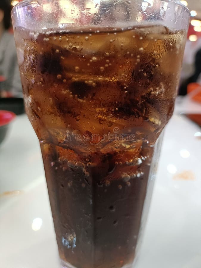 Photo Cola in a Glass with Ice Cubes on a Table in a Restaurant Stock ...