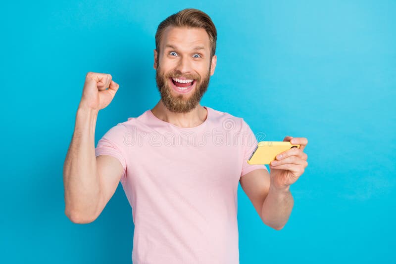 Photo Of Cool Lucky Young Man Wear Pink T Shirt Rising Fist Browsing
