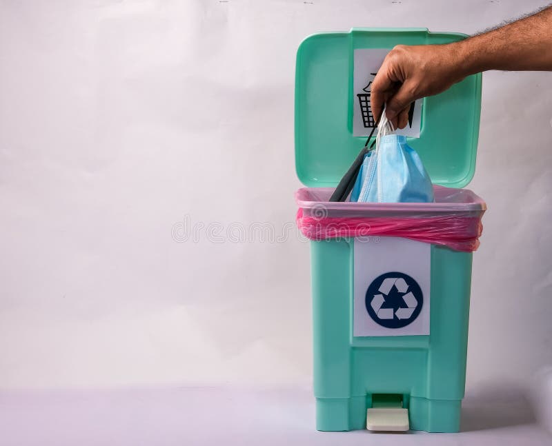 Photo of Disposing Face Masks in a Plastic Trash Bin Stock Photo ...