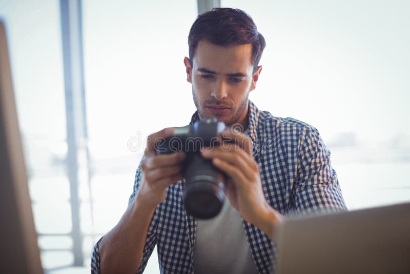 Photo Editor Holding Camera while Sitting in Office Stock Image - Image ...