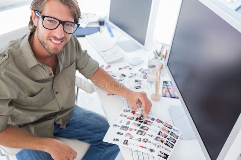 Photo Editor Looking Up from His Work at Desk Stock Image - Image of ...