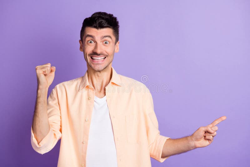 Photo Of Hooray Brunet Guy Hand Fist Point Empty Space Wear Peach Shirt