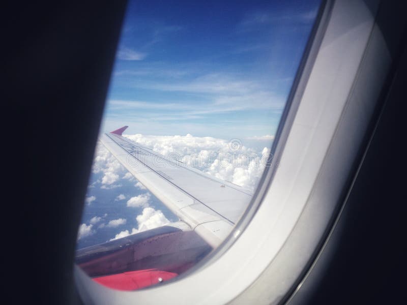 A Photo from Inside the Plane that Shows Clouds and Airplane Wings ...